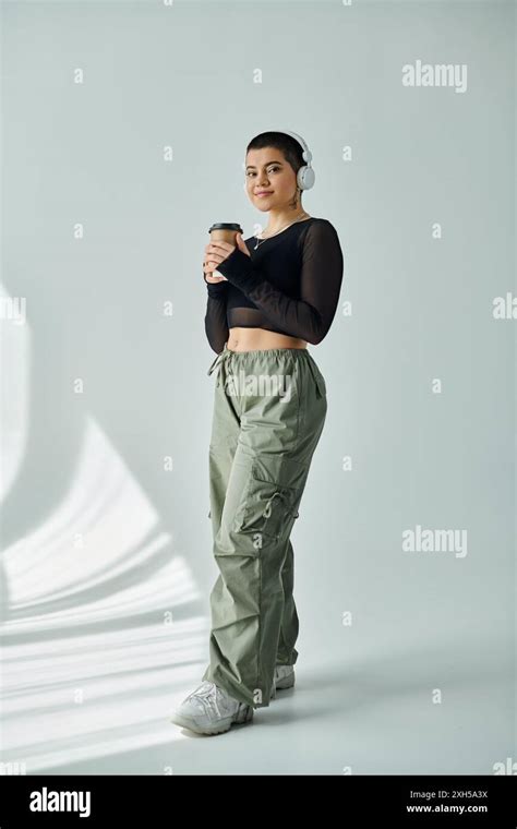 A Stylish Young Woman With Short Hair Strikes A Confident Pose In Front