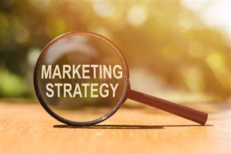 Magnifying Glass With Text Marketing Strategy On Wooden Table Stock