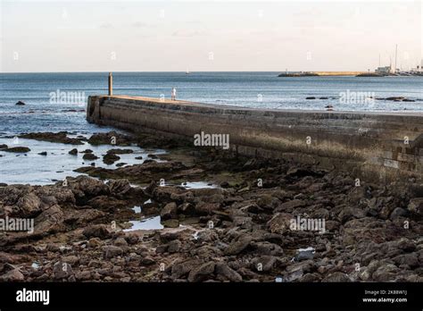 An Old Looking Promenade Surrounded With A Sea And Boats Between