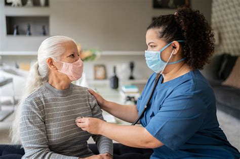 간호사가 가정 방문 중에 수석 환자의 심장 박동을 듣고 보호 얼굴 마스크를 착용 2명에 대한 스톡 사진 및 기타 이미지 2명