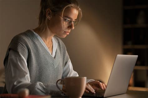 Mujer De Tiro Medio Trabajando Tarde En La Noche Foto Gratis