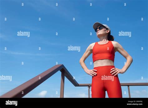 Fit Sporty Woman Standing With Hands On Her Hips Looking Off Resting