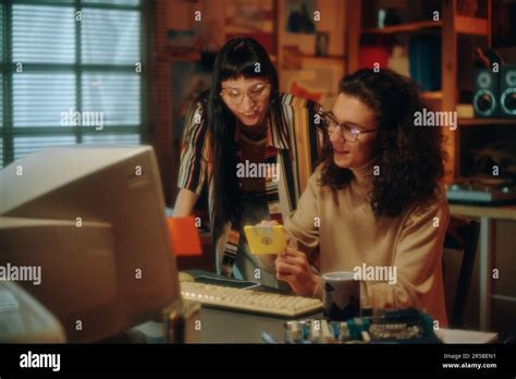 Young People Using Floppy Disk To Save Information From Computer During Their Teamwork In Garage