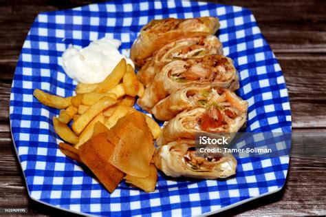 시리아 조리법 요리 배경 양파 토마토 양상추 및 마늘 소스를 곁들인 치킨 샤워마 또는 샤워마 토틸라 랩 한 접시에 사이드 프렌치 프라이와 튀긴 빵이있는 시리아 빵 샌드위치