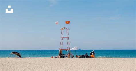 햇볕이 잘 드는 해변에 인명 구조원 타워가 서 있습니다 사진 Unsplash의 무료 바닷가 이미지