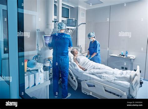 Nurses In Intensive Care Unit Of Hospital Checking Vitals Of