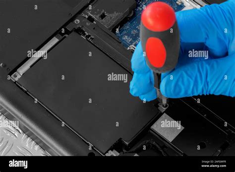 Technician Installing Hard Drive HDD To A Laptop Computer Using Screwdriver Computer Updrade