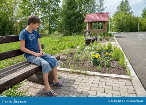 Een Peinzende Jongen Van 11 Jaar Oud Zit Op Een Houten Bank In Het Park