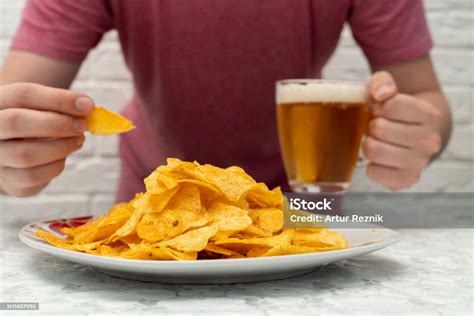 감자 칩 접시에 칩을 들고 차가운 맥주 한 잔 건강에 해로운 음식을 들고있는 남성 손 0명에 대한 스톡 사진 및 기타 이미지
