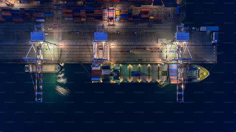 Aerial Top View Container Ship At Sea Port And Working Crane Bridge