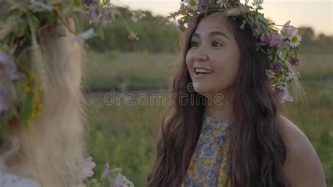 Midsummer Two Girls Are Talking And Weaving Wreaths In The Field Stock