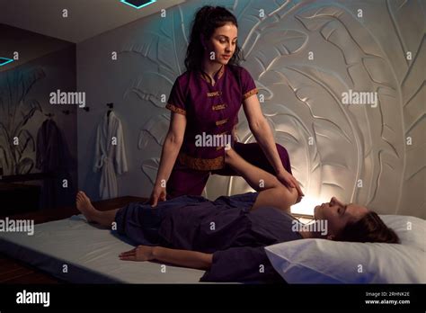 Skilled Massage Therapist Stretching Patient Muscles Of Lower