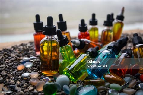 Vape 개념입니다 아름 다운 화려한 Vape 액체 유리 병 돌에 야외 배경 또는 전자 담배 광고로 유용 합니다 전자담배에 대한