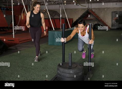 Women Doing Weight Sled Push In Gym Stock Photo Alamy