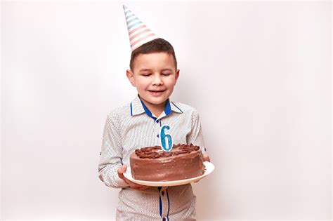 숫자 6의 형태로 촛불이 달린 생일 케이크를 들고 있는 쾌활한 소년 생일 축하 개념입니다 6에 대한 스톡 사진 및 기타 이미지