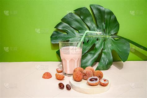 粉红色的桌子上放着新鲜的冰沙和荔枝水果