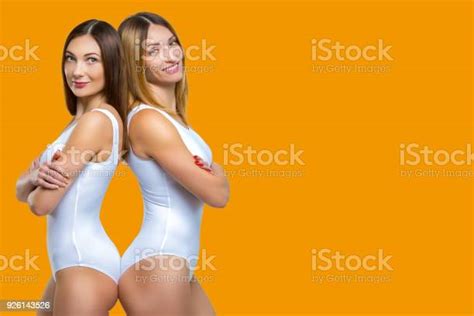 흰색 수영복에 두 명의 화려한 웃는 여자의 초상화 오렌지 배경 사진 2명에 대한 스톡 사진 및 기타 이미지 2명 가냘픈
