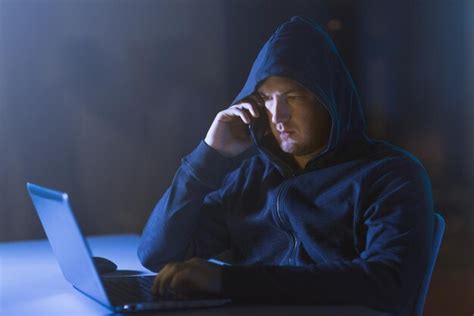 Premium Photo Hacker With Laptop Calling On Cellphone