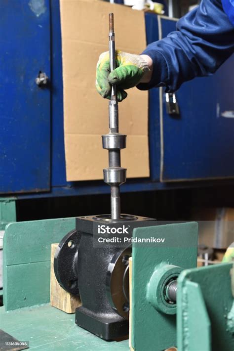 밸브의 베이스는 공장에서 조립 하기 위해 바이스에 설치 되 고 클램핑 되며 작업자는 구성품을 설치 하 고 고정 합니다 강철에 대한 스톡 사진 및 기타 이미지 Istock