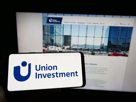 Person Holding Mobile Phone With Logo Of German Investment Company