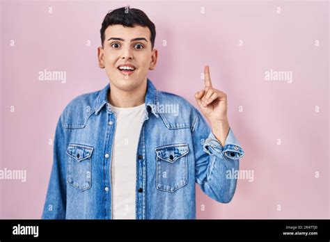 Non Binary Person Standing Over Pink Background Pointing Finger Up With Successful Idea Exited