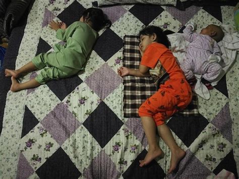 Premium Photo High Angle View Of Girl Sleeping With Sisters On Bed At