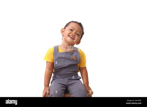 Adorable Asian Girl Is Sitting And Look At Camera Isolated On White