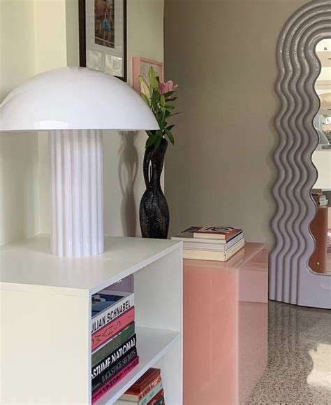 There Is A Lamp And Some Books On The Shelf In This Living Room With