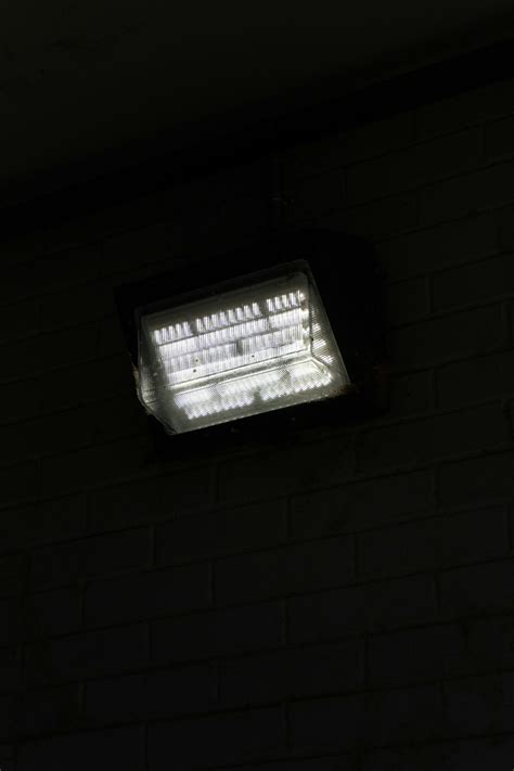 밝은 빛이 어두운 벽돌 벽을 비춥니다 사진 Unsplash의 무료 건물 이미지