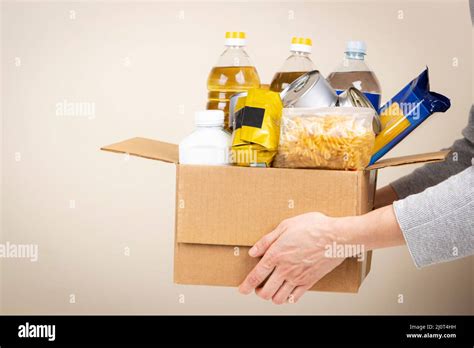 Woman Hands Holding Cardbox With Grocery Products Volunteer Collecting