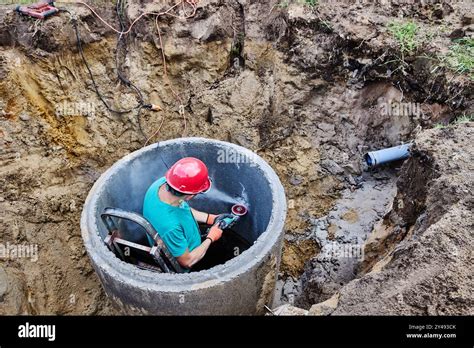 homeowner uses diamond circular saw to create hole for sewer pipe while