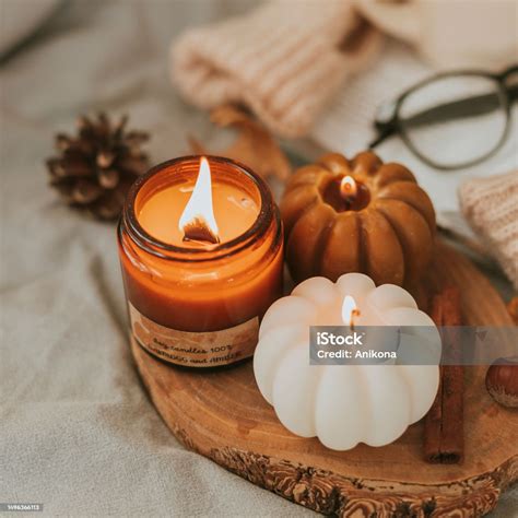 나무 심지가 있는 유리병에 향기로운 양초와 호박의 양초 모양 머그잔에 레몬 차가 있는 가을 구성 아로마테라피 명상 웰빙의 개념 촛불 조명 장비에 대한 스톡 사진 및 기타