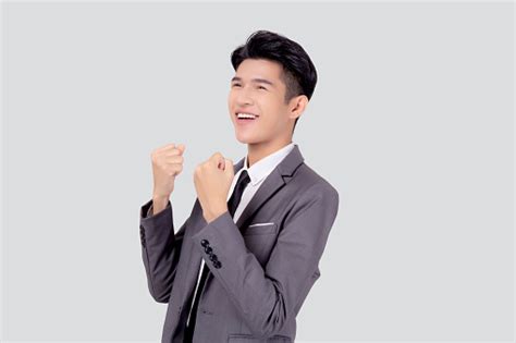 흰색 배경에 고립 된 승리 성공과 함께 서 정장 사업가 젊은 아시아 사업가는 자신감과 흥분을 가진 관리자 또는 임원긍정적 인