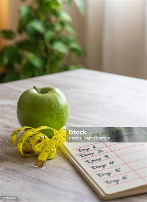 균형 잡힌 영양 목표와 건강한 식단을 상징하는 녹색 사과를 특징으로 하는 건강 및 피트니스 일일 식사 계획 저널