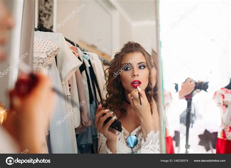 Portrait Of Girl Putting Lipstick On Her Lips And Looking In Mirror