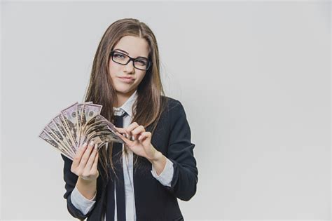 집중 된 젊은 비즈니스 여성은 돈의 더미를 계산 흰색 배경에 고립 소녀는 달러의 둥근에 의해 만족 스 럽 고 혐오와 카메라를