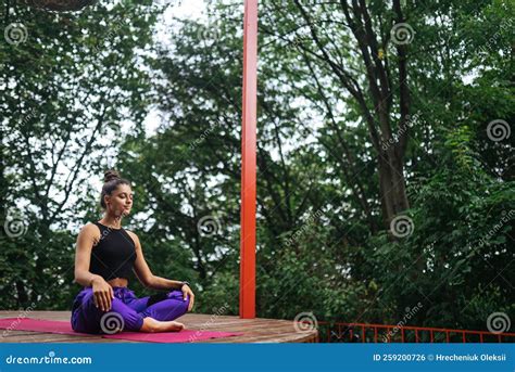 Young Woman Is Practising Yoga Sitting In The Lotus Position Stock