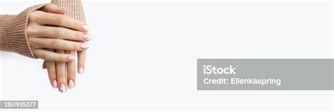 가벼운 배경에 파스텔 베이지 매니큐어 잘 손질 된 손톱과 부드러운 손 피부 살롱 배너 와 복사 공간 따뜻한 스웨터를 입은 여성의