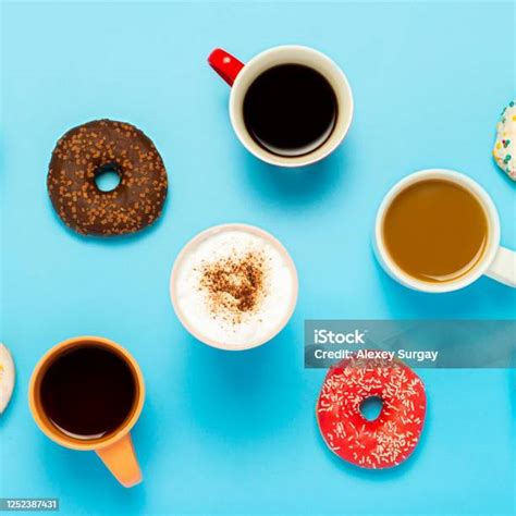 뜨거운 음료 커피 카푸치노 파란색 배경에 차를 곁들인 맛있는 도넛과 컵 과자 빵집 패스트리 커피숍 회의 친구 친절한 팀의 개념