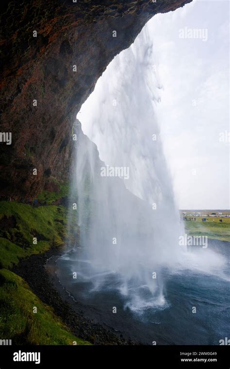 Seljalandsfoss A Famous And Unique Waterfall In Iceland With Visitors Walking Behind The Falls