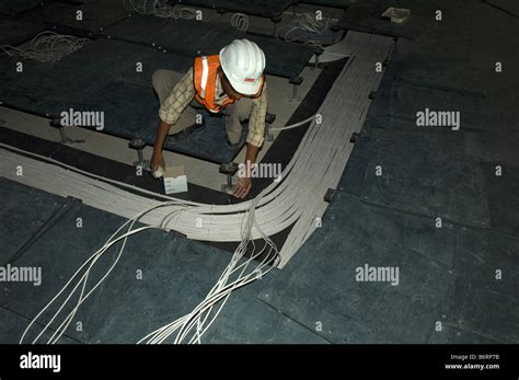 Engineer Inspecting A Structured Cabling Installation Under A Raised