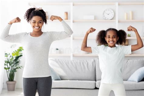 Madre E Hija Afroamericana Fuerte Mostrando Sus Músculos Imagen de