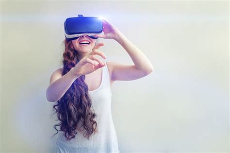 흰색 배경에 가상 현실 Vr 안경 헬멧 헤드셋을 사용하여 착용 젊은 여성을 미소 가상 현실 고글과 함께 사용하는 스마트 폰