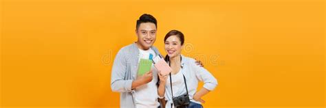 Asian Couple Holding Passports With Tickets And Hugging Isolated Over