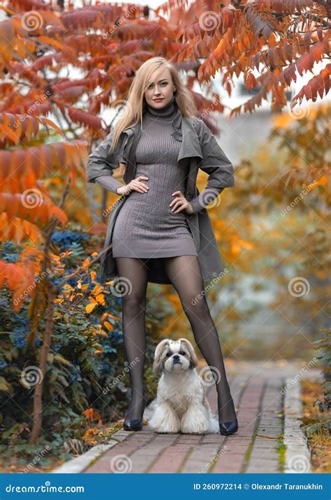 Beautiful Woman With Perfect Legs Walking In The Autumn Park With A