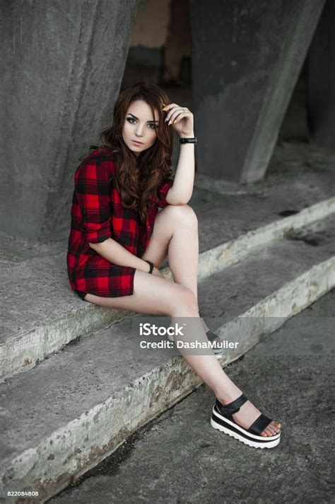 아름 다운 젊은 Hipster 소녀 빨간색 체크 무늬 셔츠 반바지 야외에서 여름 초상화에 도시 벽 배경 근처 웃 고 포즈 거리에