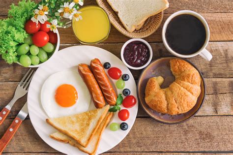 홈메이드 아침 식사 계란 토스트 소시지 과일 야채 크로 딸기를 햇볕이 잘 드는 측면 상단 보기에 블랙 커피와 오렌지 주스 잼 플랫 누워 개념 맛 있는 수 제 미국식 아침