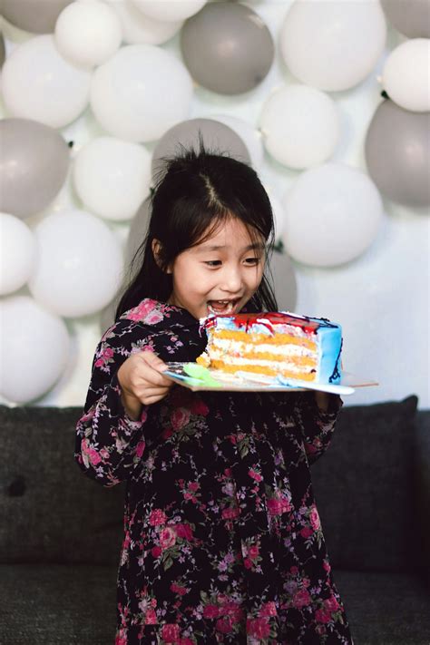 검은 색과 분홍색 꽃 긴 소매 셔츠 들고 케이크를 들고 소녀 사진 Unsplash의 무료 생일 케이크 이미지