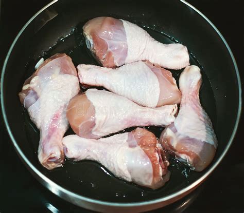 Top View Raw Chicken Legs Are Fried In A Pan On An Electric Stove