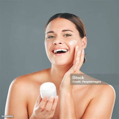여자는 얼굴에 크림을 바르고 초상화와 아름다움 스킨케어 모이스처라이저에 만족하며 스튜디오 배경에 고립되어 있다 자외선 차단제
